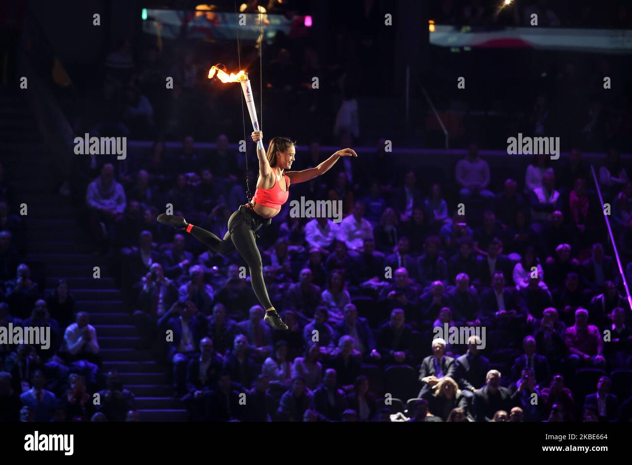 A performer brings the the torch to light the cauldron during Opening ...