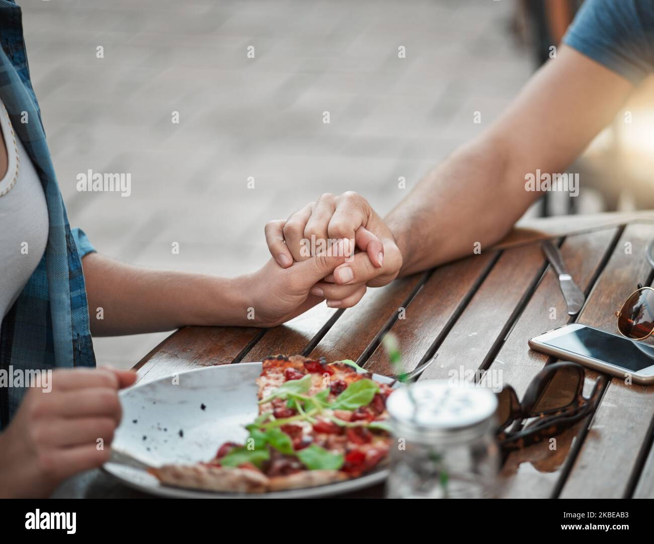 We always hold hands at dinner. two unrecognizable people holding hands ...