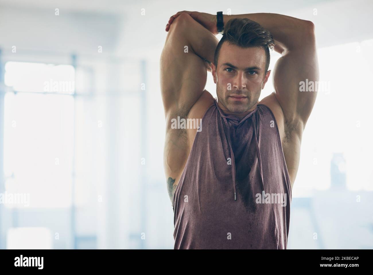 Stretch to create the best muscles. a handsome young man stretching at ...