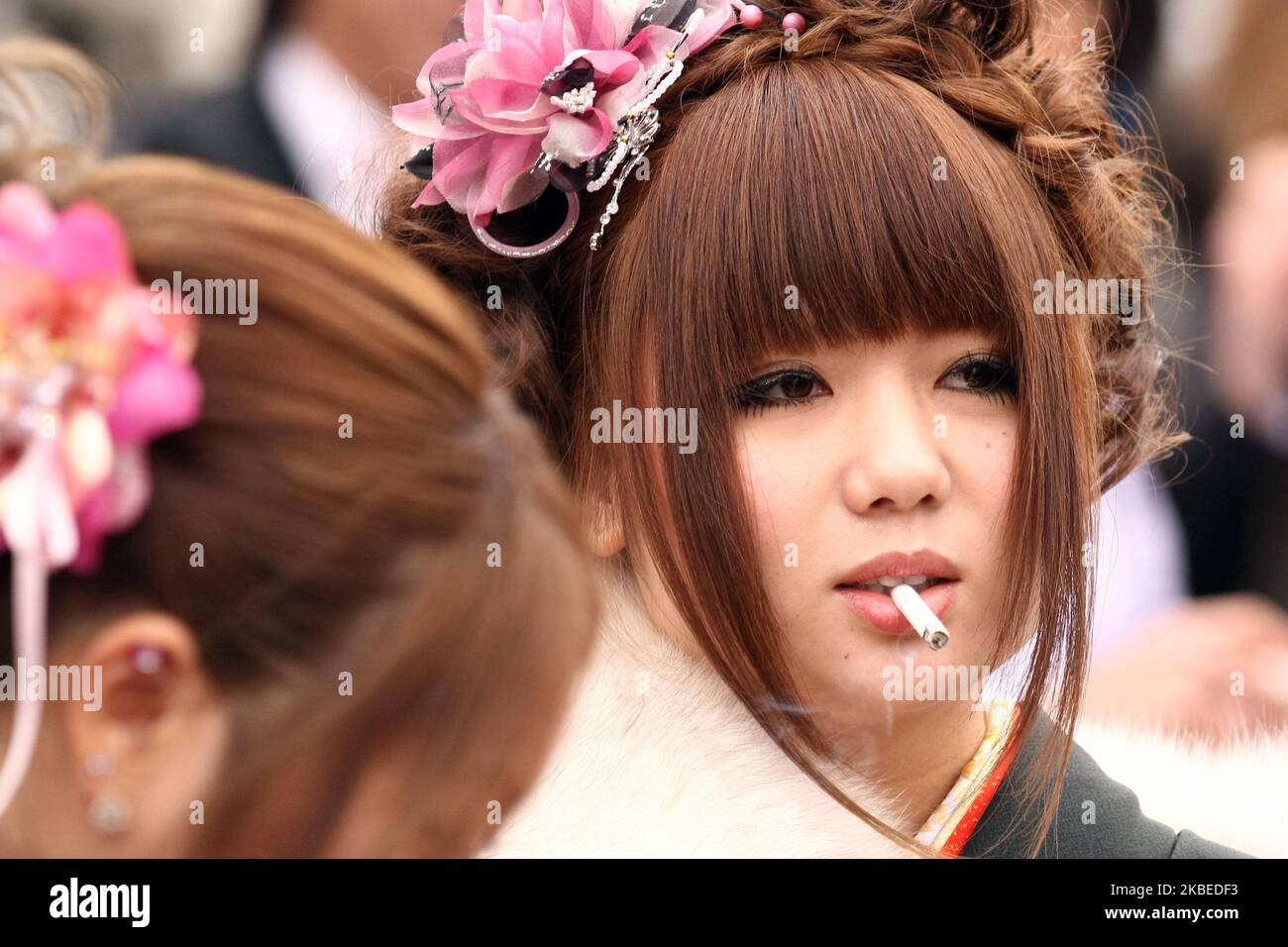 A Japanese woman smokes a cigarette at a ceremony celebrating the ...