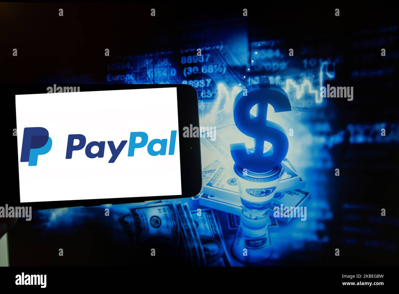 The logo of Paypal is seen on a screen of a smartphone next to an ...