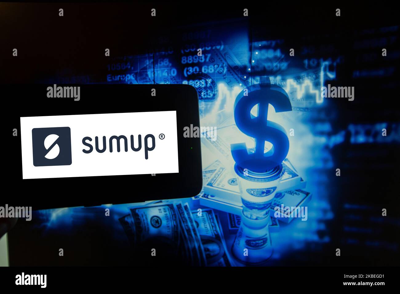 The logo of SumUp is seen on a screen of a smartphone next to an ...