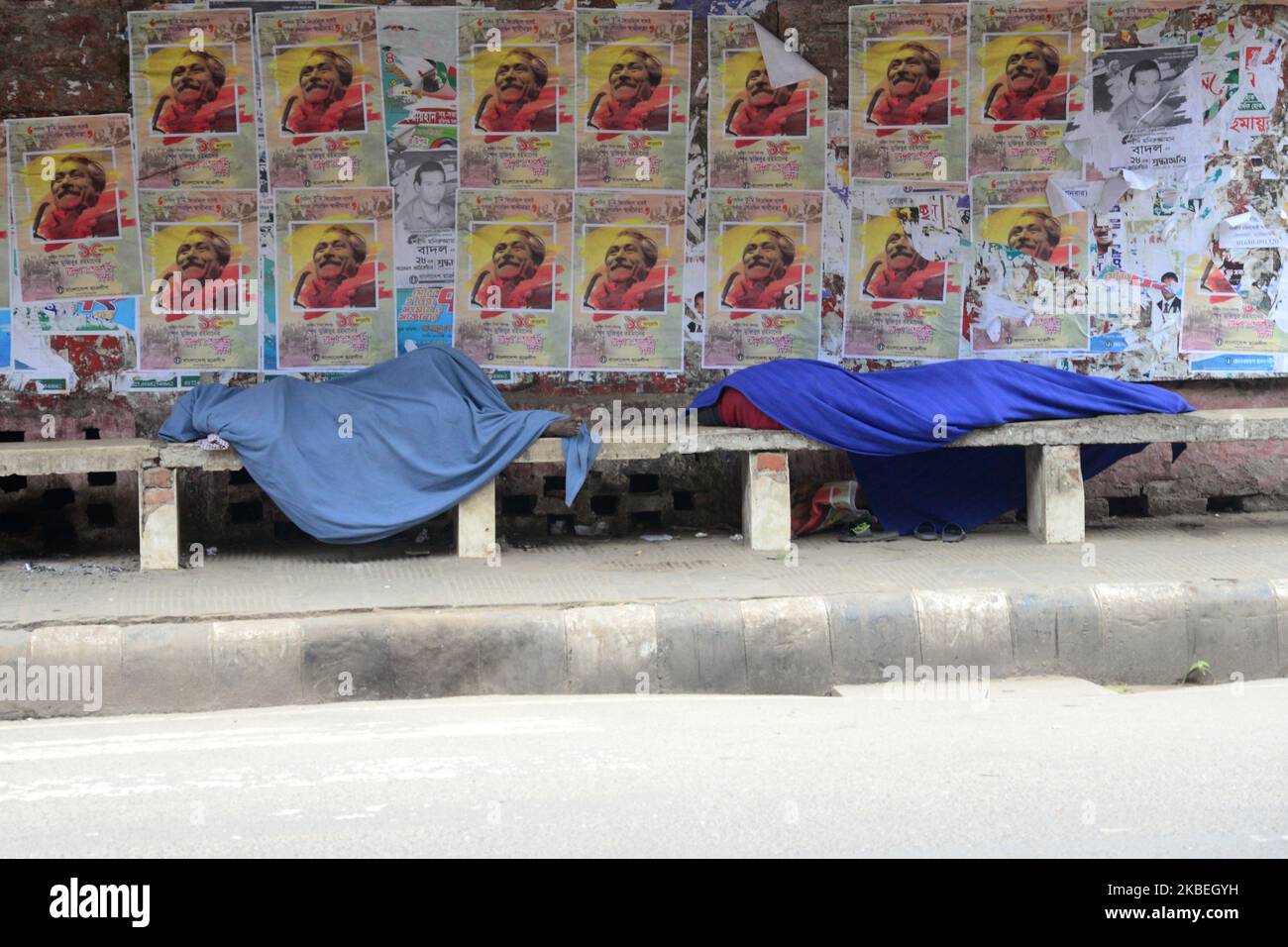 Bangladeshi homeless people sleep on the road side footpath in a winter ...
