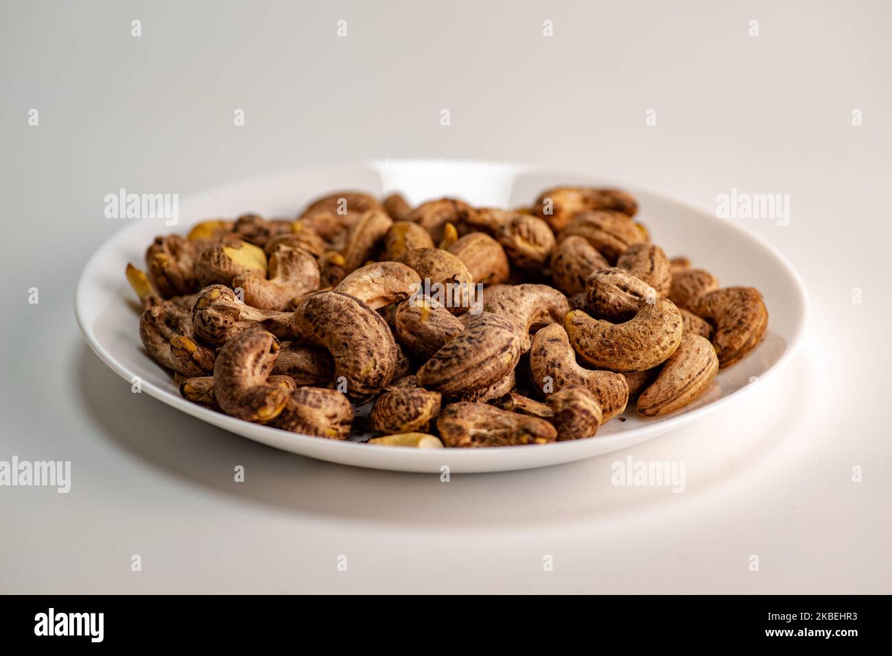 Close up of roasted cashew nuts with skin on white background Stock ...