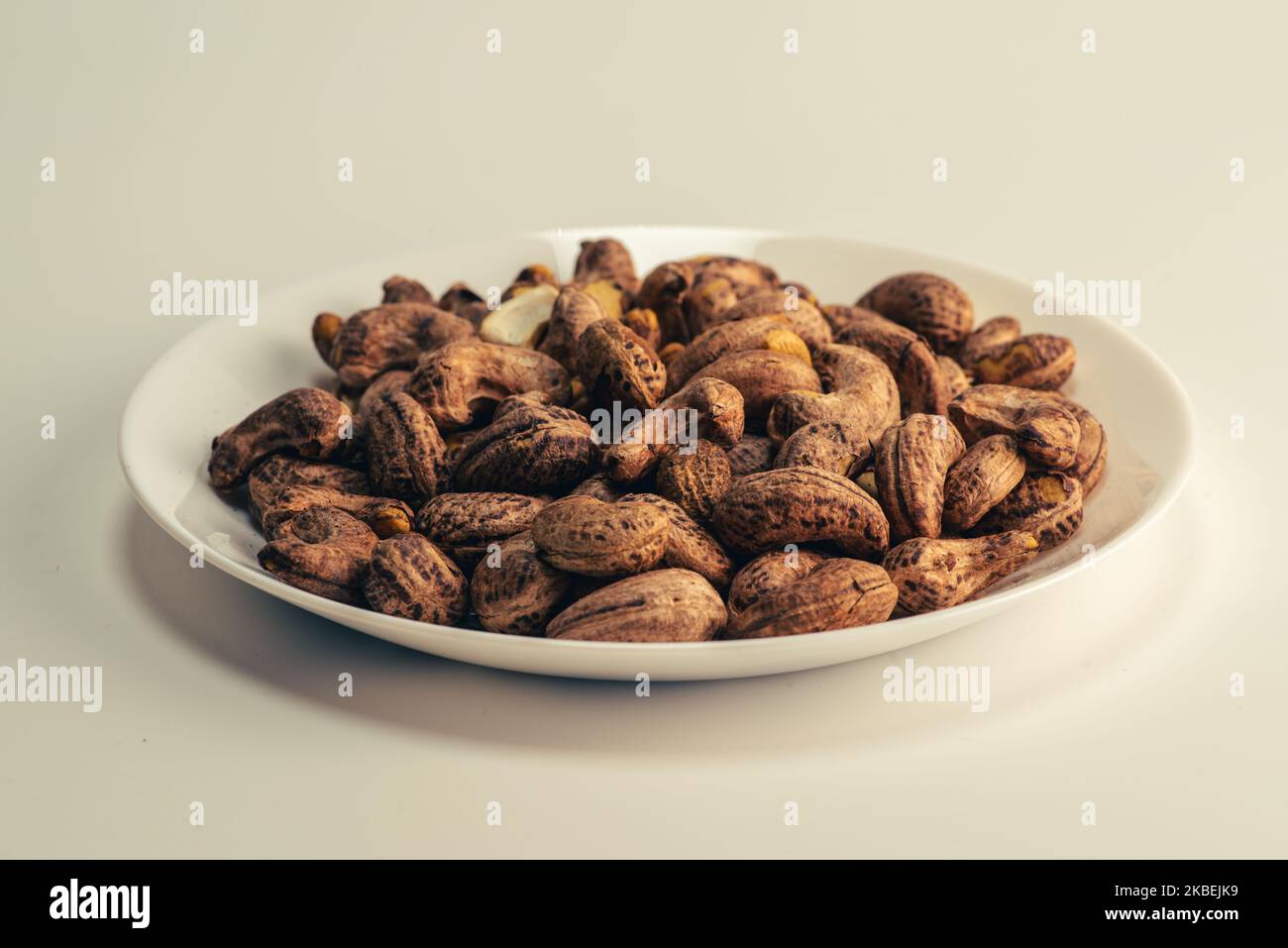 Close up of roasted cashew nuts with skin on white background Stock ...