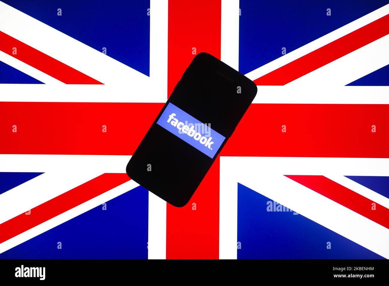 Facebook logo is displayed on a mobile phone screen photographed on UK ...