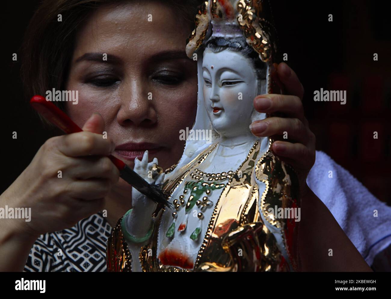 A woman cleans the statue at Dhanagun Temple, Bogor, West Java, on ...