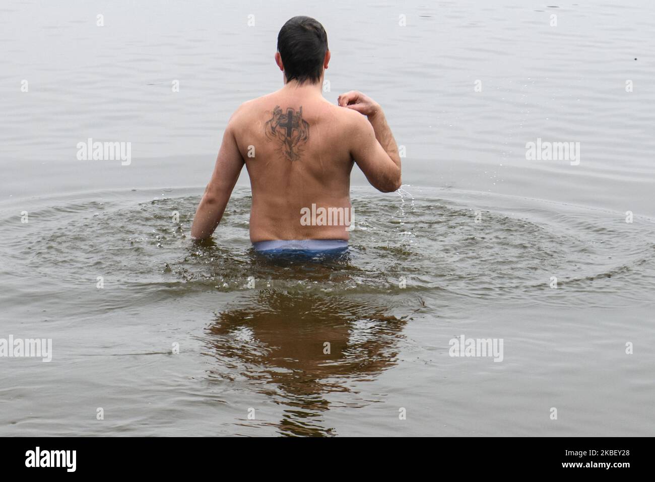 People walk into icy waters to take a dip during celebrations of the ...