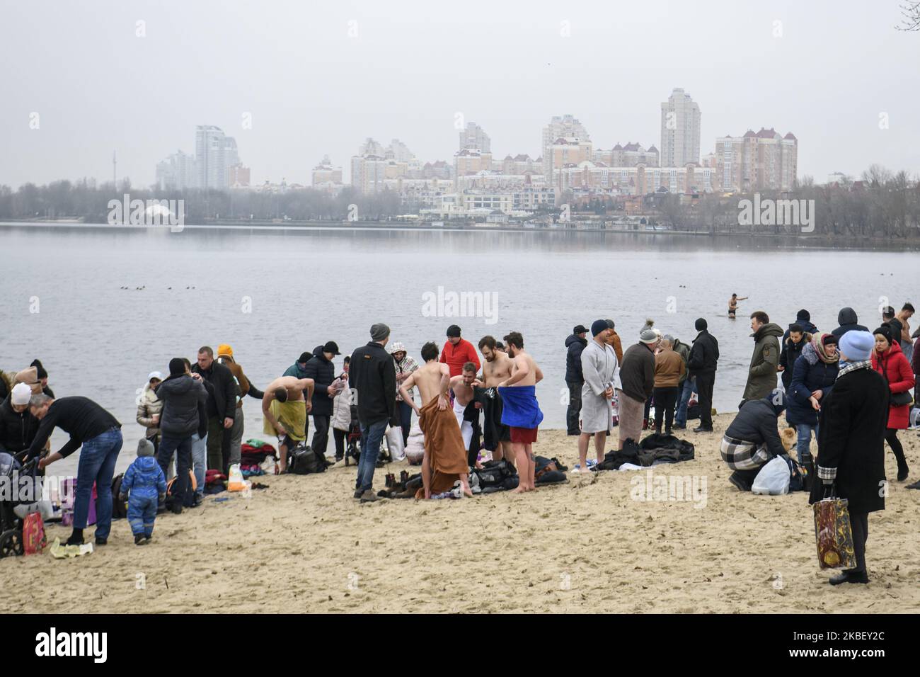 People walk into icy waters to take a dip during celebrations of the ...