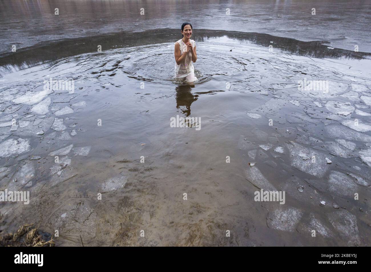 A woman takes a dip ice bath inside a frozen lake to celebrate the ...