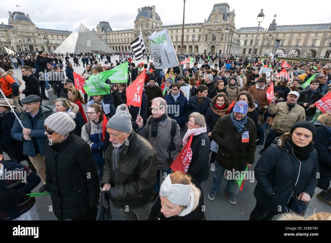 Protesters hold flags in front of the Louvre Museum during a ...