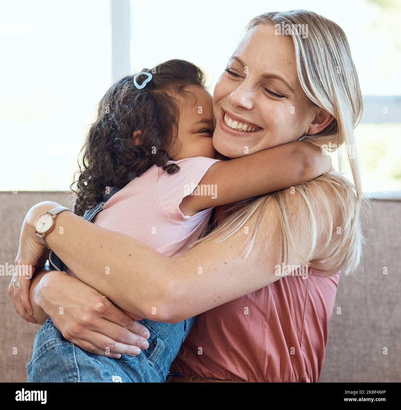 Mother, hug and child love on a home living room sofa feeling ...