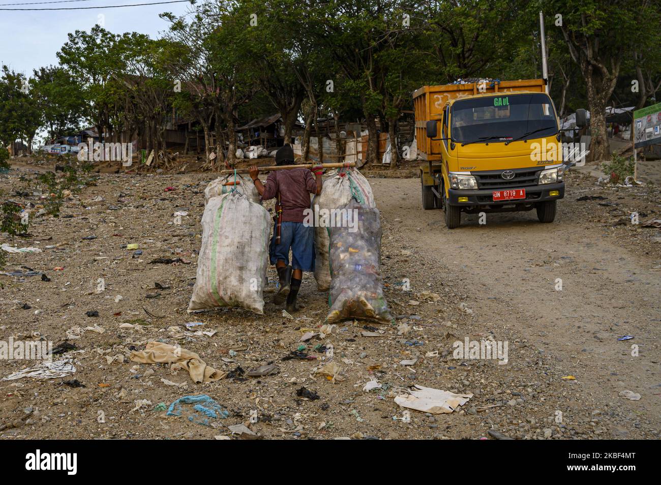 A scavenger carries plastic waste that has been collected for recycling ...