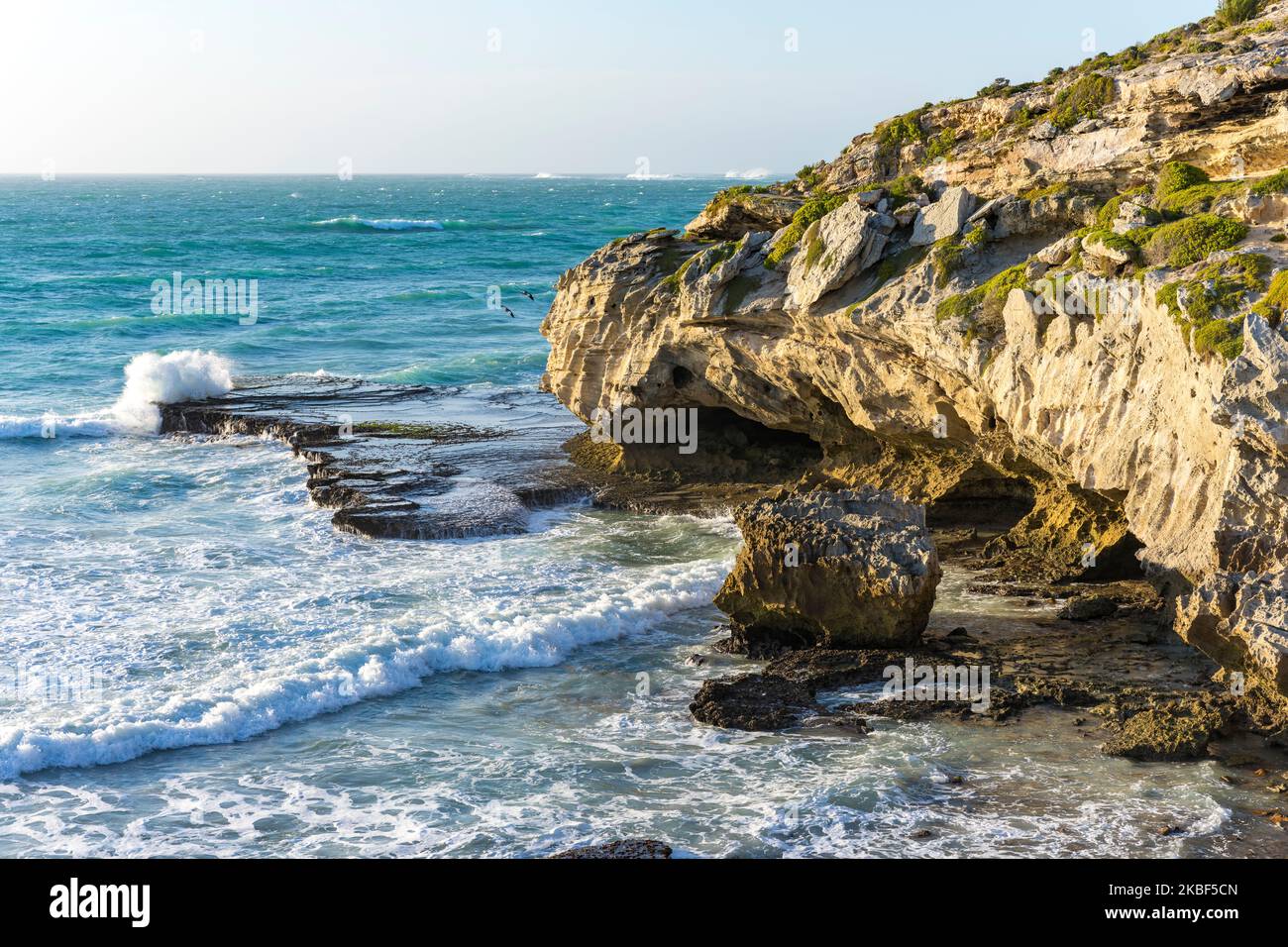 Scenic view of Waenhuiskrans sea-cave and rugged rocky shoreline at ...
