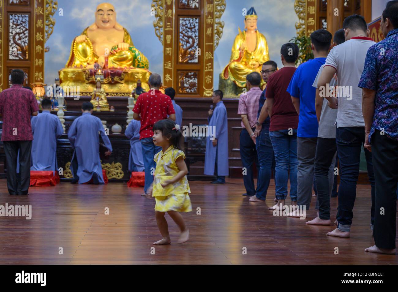 A child crosses among Chinese citizens who will perform prayers to ...