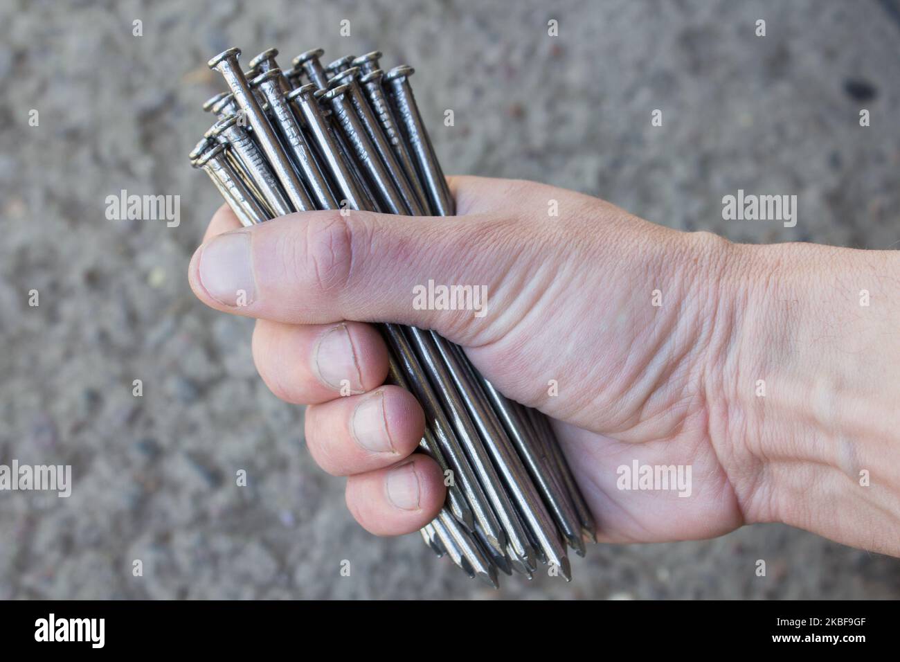 hold in hand heap of metal nails for work Stock Photo - Alamy