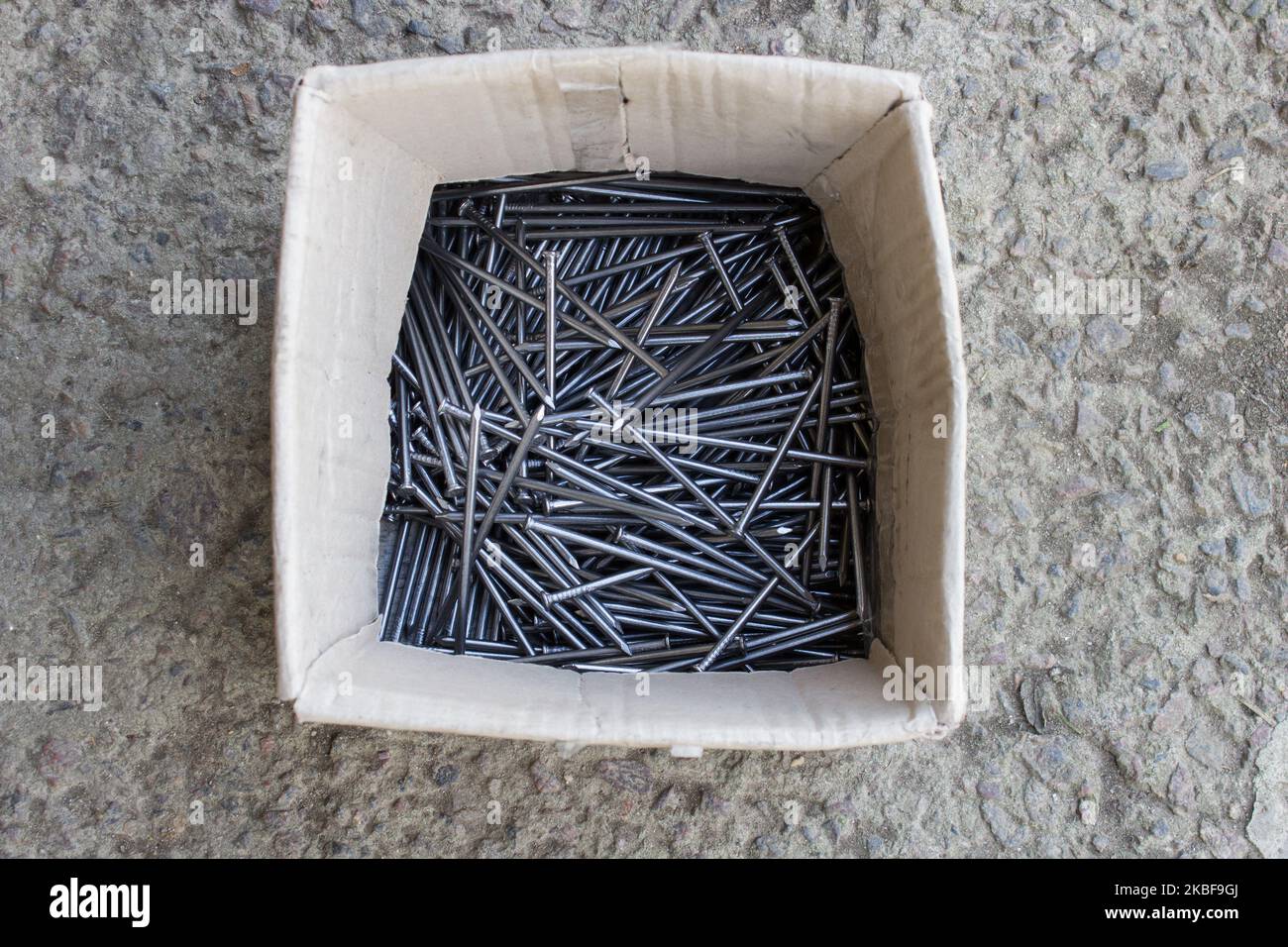 New nails in cardboard box top view Stock Photo - Alamy
