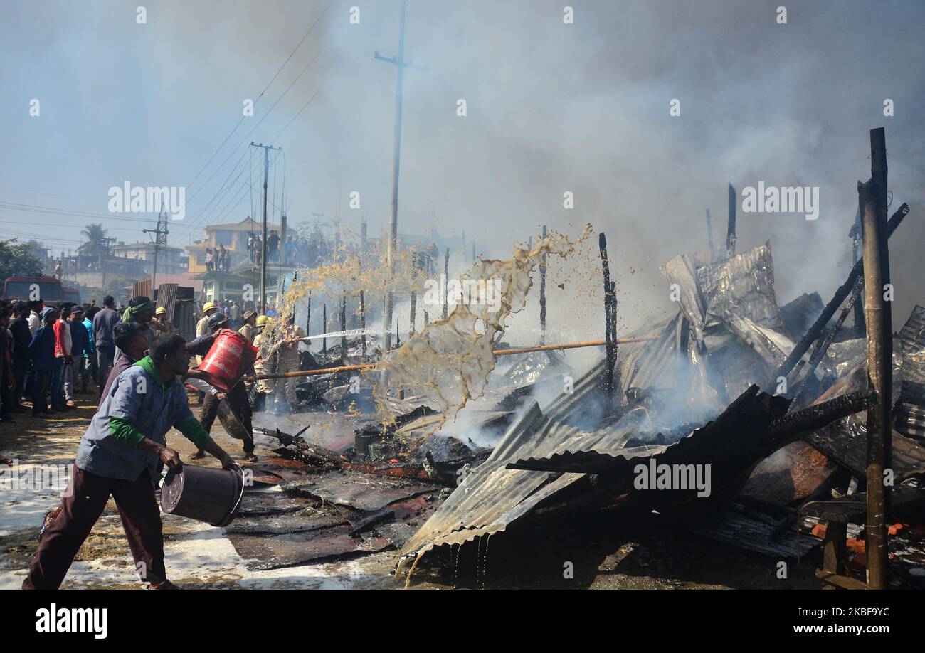 Fire Fighter and residents spray water to extinguish a fire which broke ...