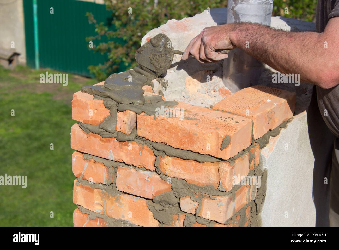 Builder mason building a chimney on the roof Stock Photo - Alamy