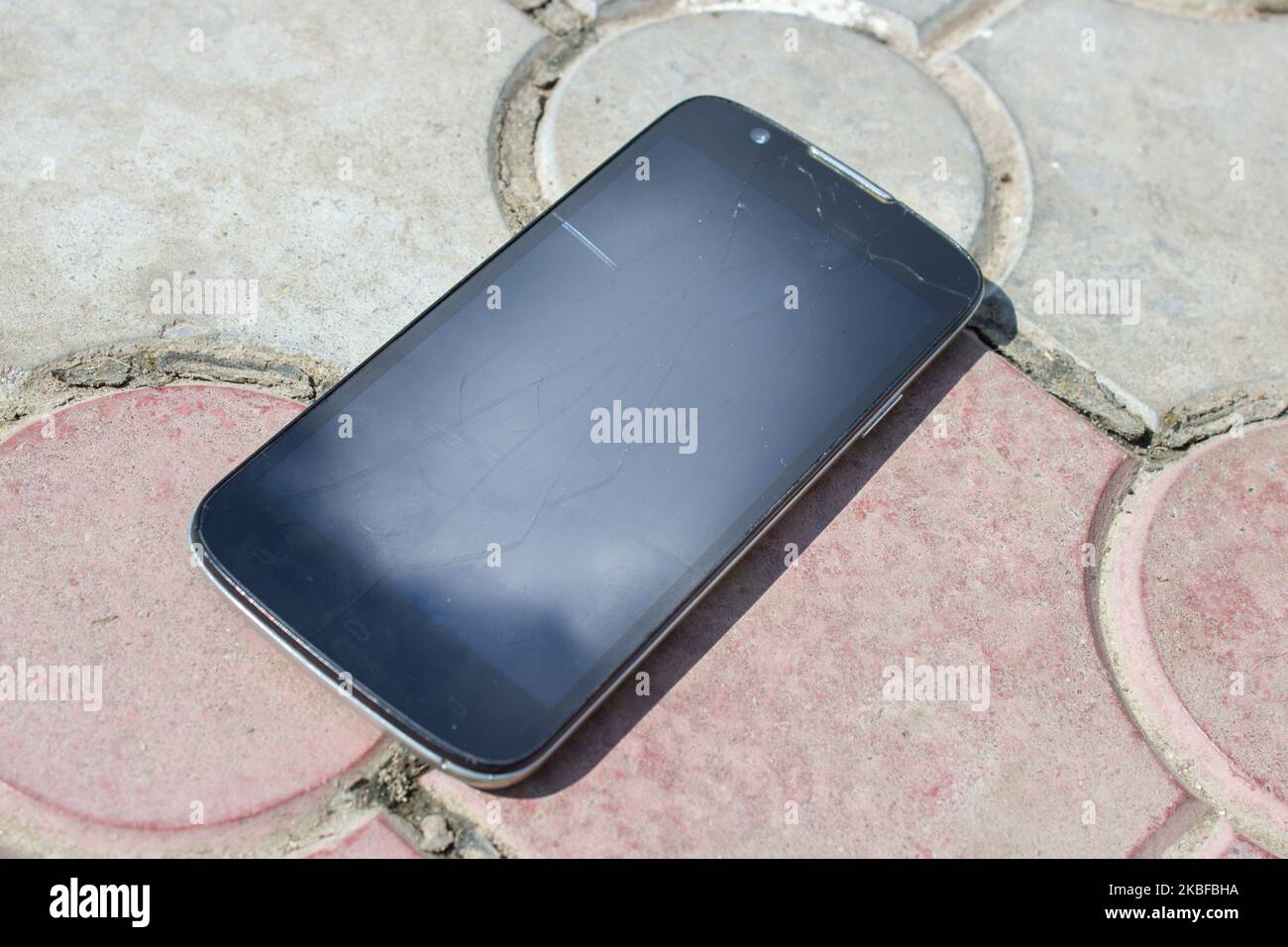 Cracked mobile smartphone smashed by a stone greyscale with blue Stock ...