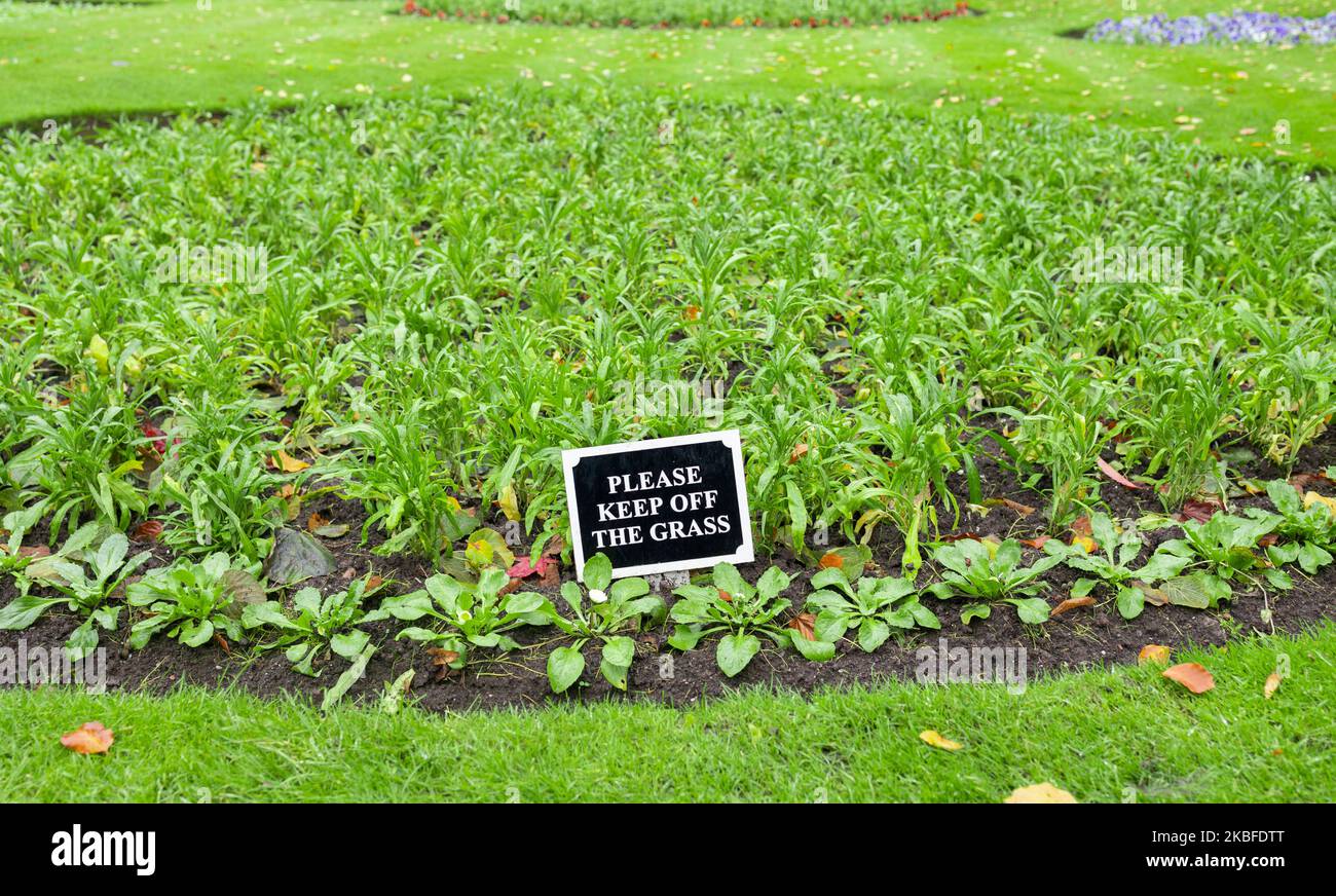Please keep off the grass sign in a community garden Stock Photo - Alamy