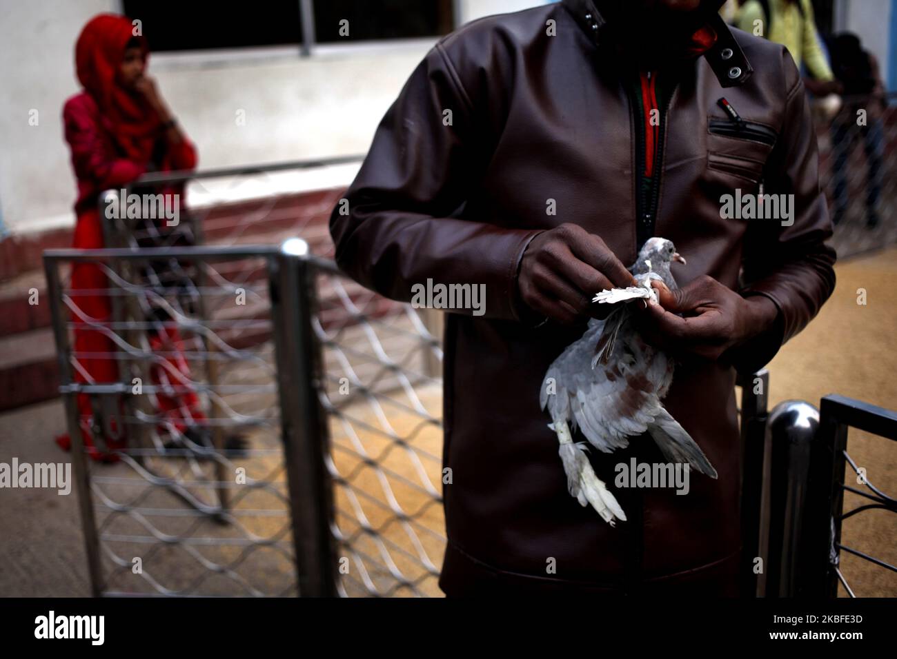 A devotee holds a pigeon as he visits Hazrat Shahjalal Mazar Sharif ...