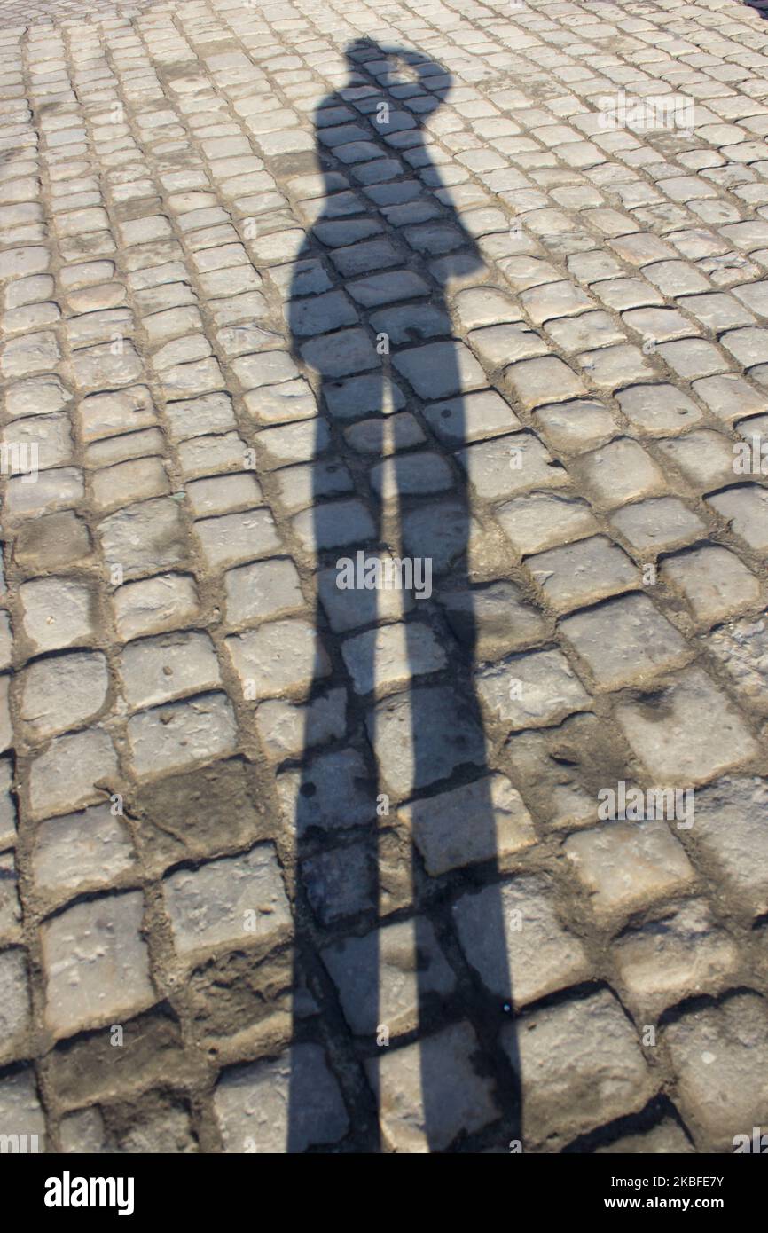 Shadow of a man with big feet on the pavement Stock Photo - Alamy