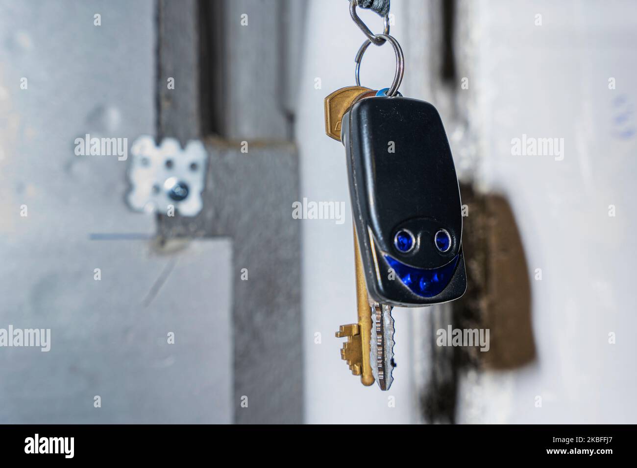 a bunch of keys and a keychain with buttons hang on a hook Stock Photo ...