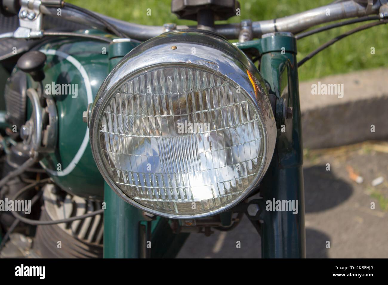 Retro motorcycle round headlight wars with close Stock Photo - Alamy