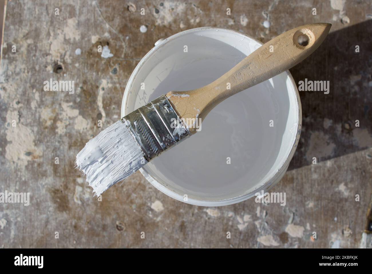 Brush in white paint in a bucket viewed from above Stock Photo - Alamy