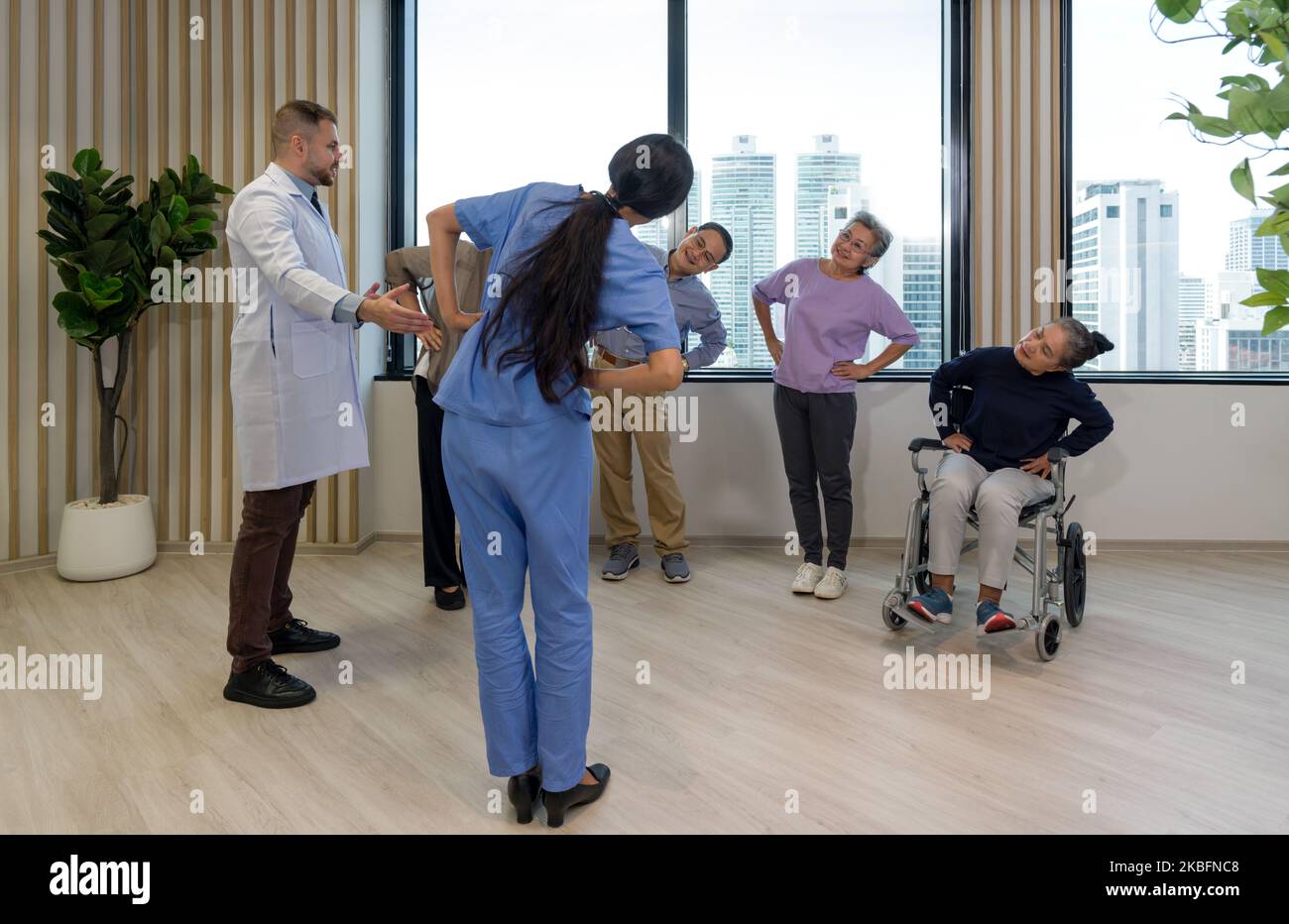 Caucasian doctor in white gown and young asian physical therapist in ...