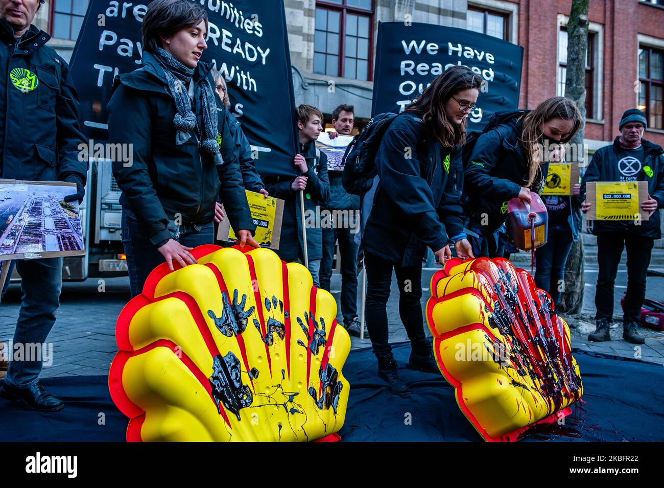 An activist is throwing fake blood over one of the Shell logos, during ...