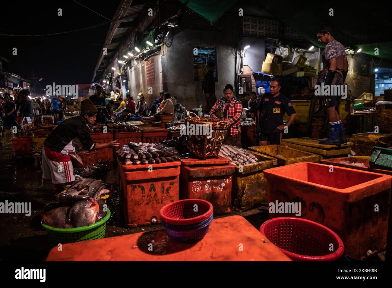 Workers sort out fishes at San Pya fish wholesale market in Yangon ...