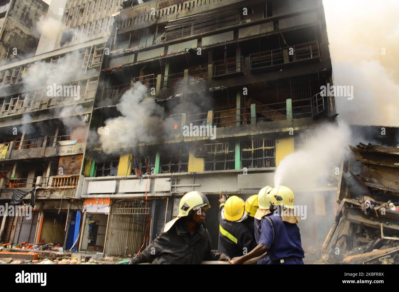 Team of fire fighters extinguishing a fire after a fire broke out in a section of the balogun ...
