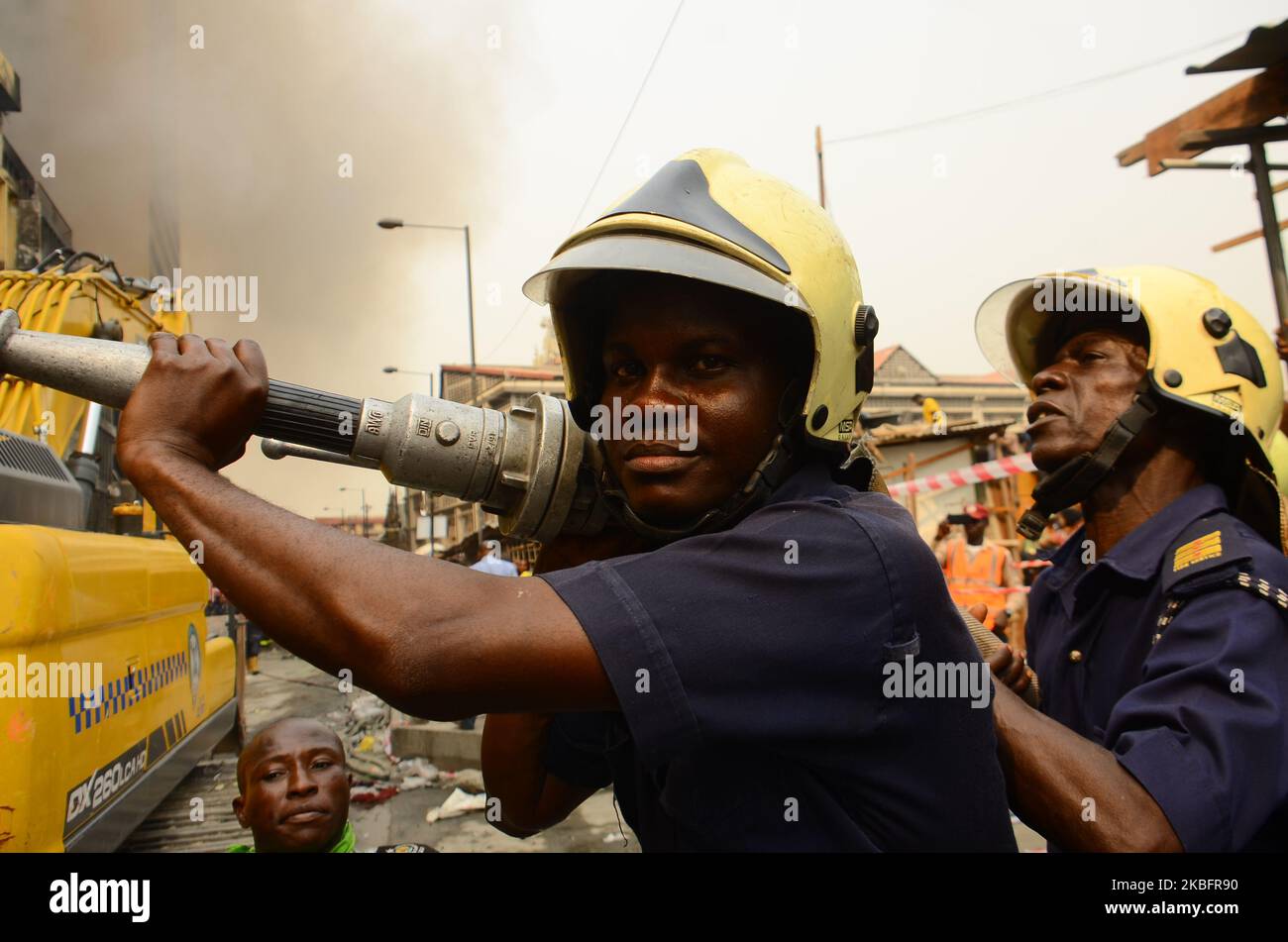 Team of fire fighters extinguishing a fire after a fire broke out in a section of the balogun ...
