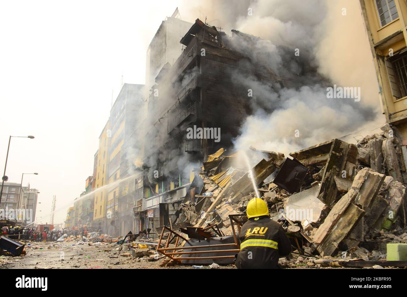 Team of fire fighters extinguishing a fire after a fire broke out in a section of the balogun ...