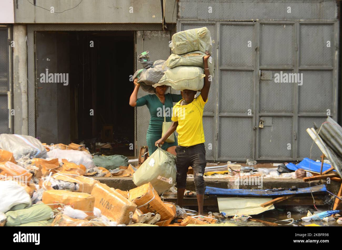 Men carries salvaged gods from shops after a fire broke out in a section of the balogun market ...