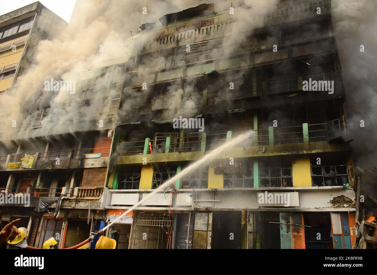 Team of fire fighters extinguishing a fire after a fire broke out in a section of the balogun ...