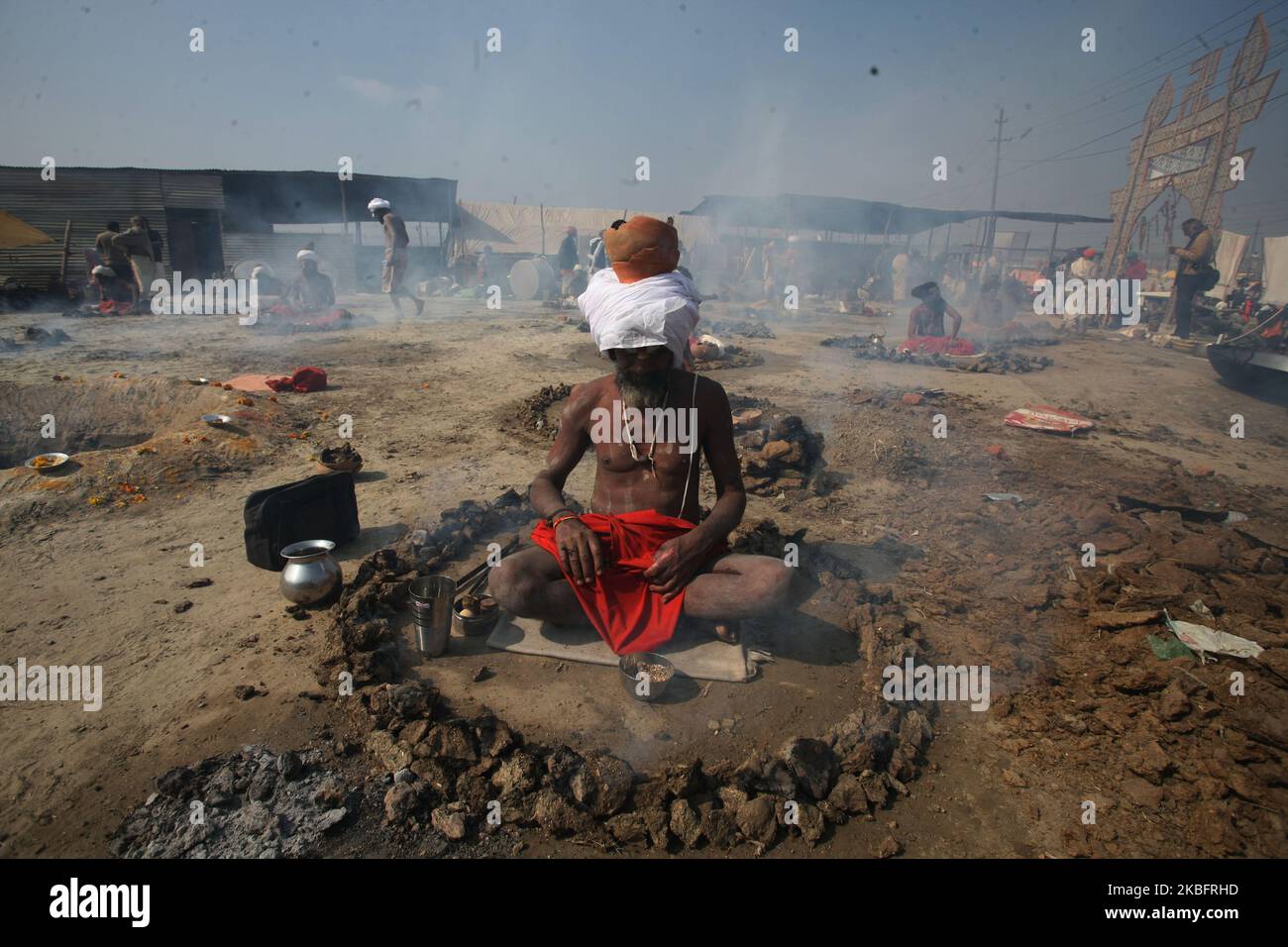 A devotee perform a ritual by burning dried cow dung cakes at sangam ...