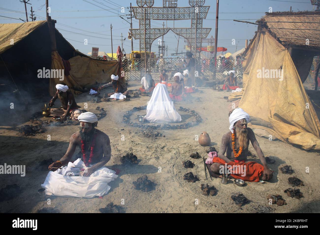 Devotees perform a ritual by burning dried cow dung cakes at sangam ...
