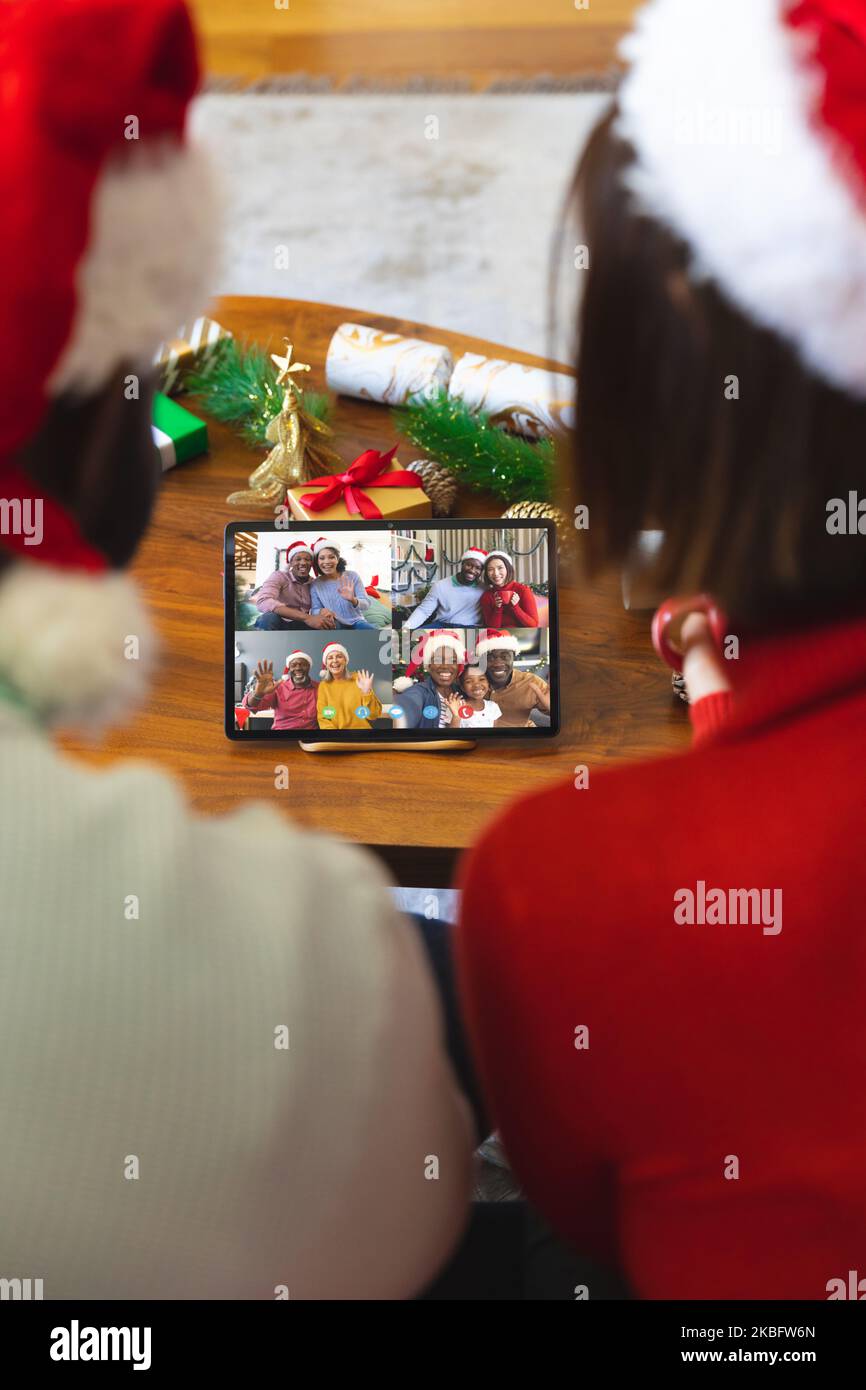 Diverse couple with christmas decorations having video call with happy ...