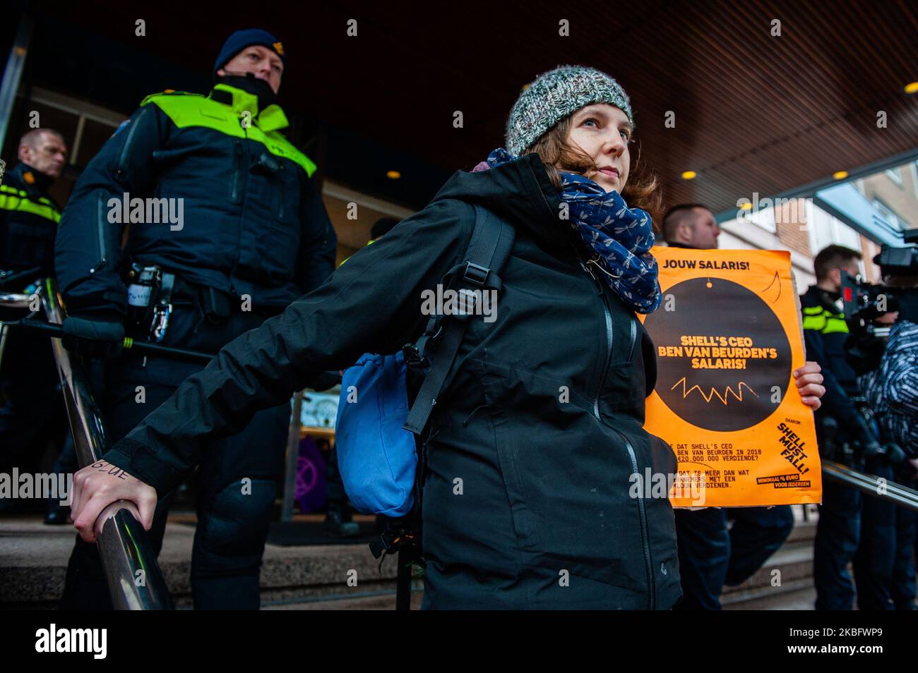 An activist is glued herself to the stairs of the Shell headquarters in ...