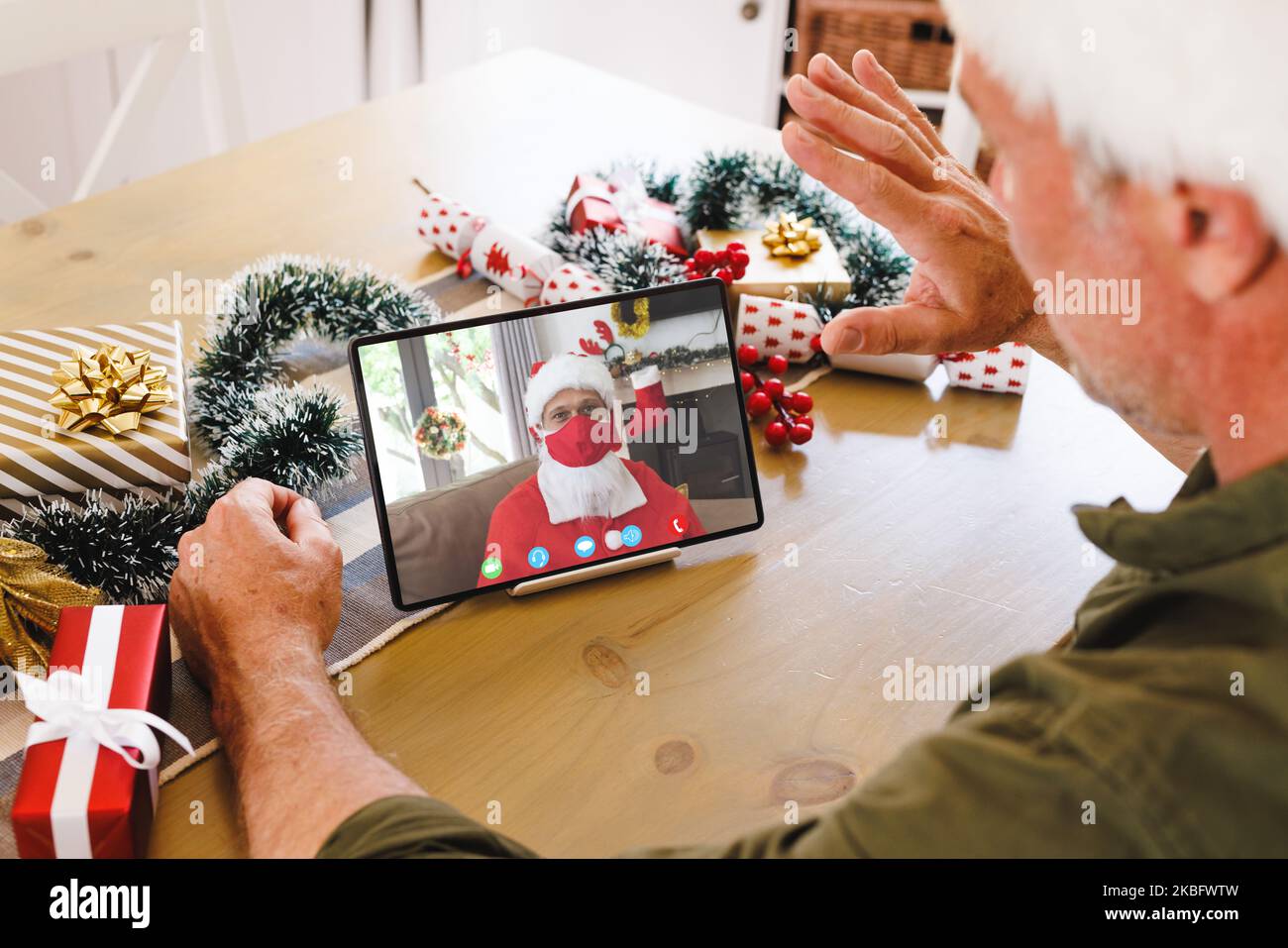 Caucasian man with santa hat having video call with santa claus with ...
