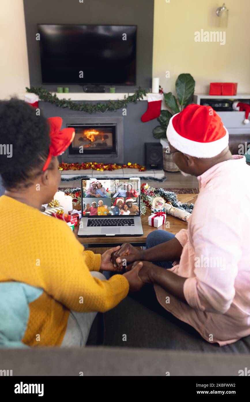 African american couple with santa hats having video call with happy ...