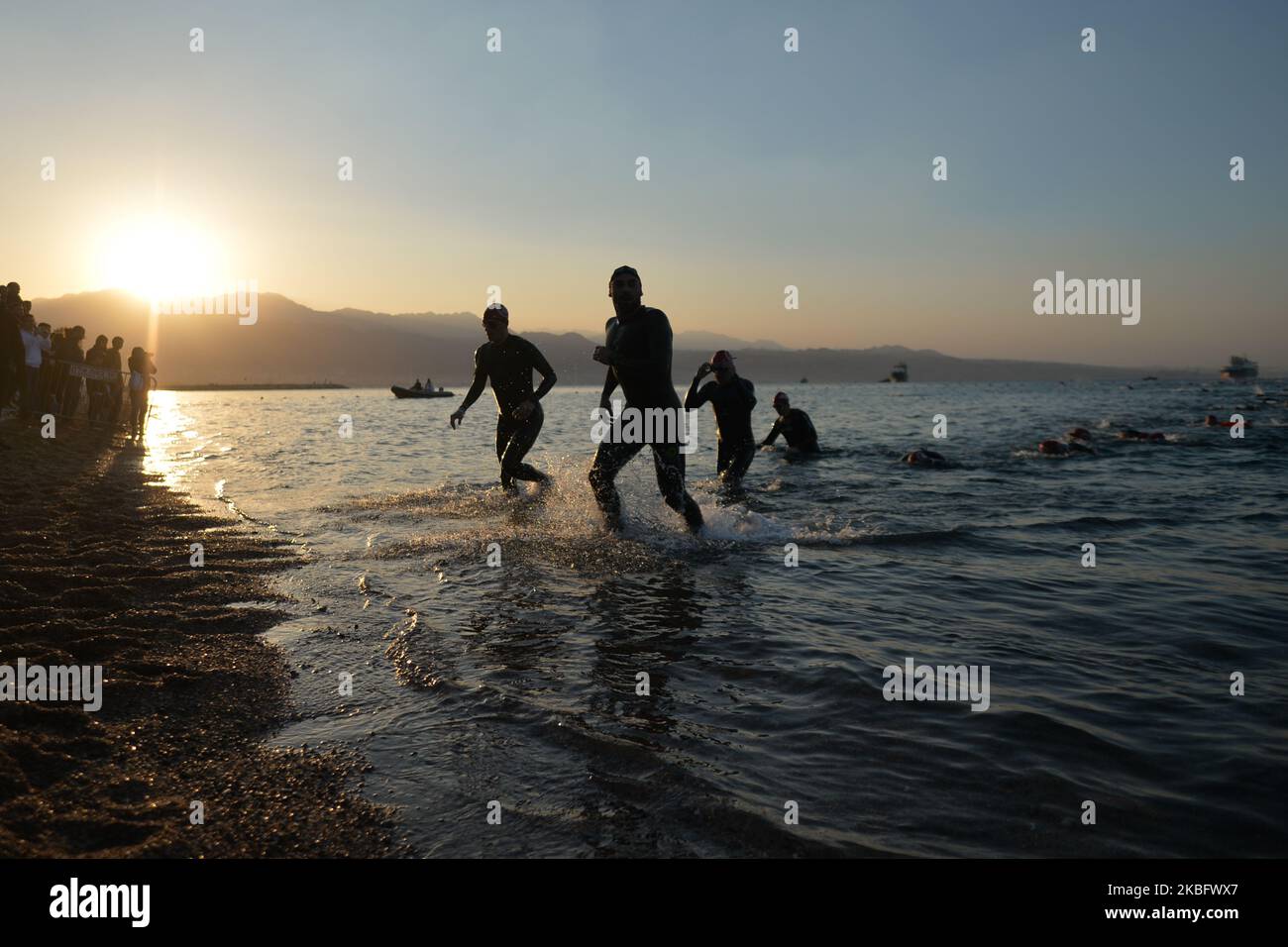 A group of athletes finishing their swim in the Red Sea during a full ...