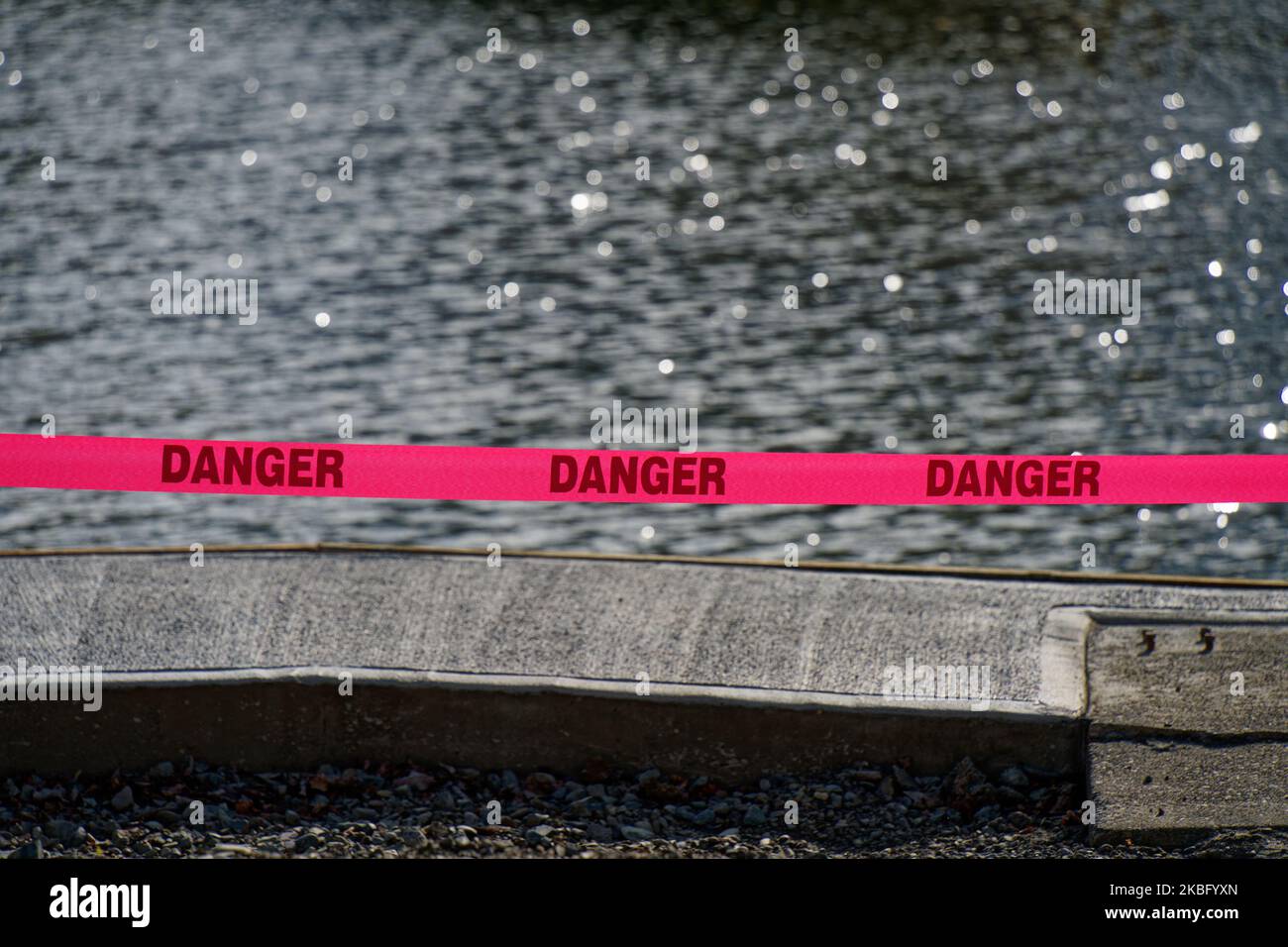 DANGER DANGER DANGER warning signage tape across a derelict jetty, the ...