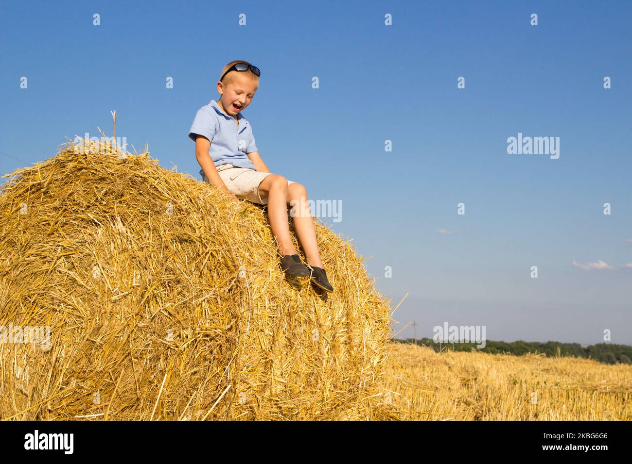 Laughing boy in the field with bundles of hay Stock Photo - Alamy