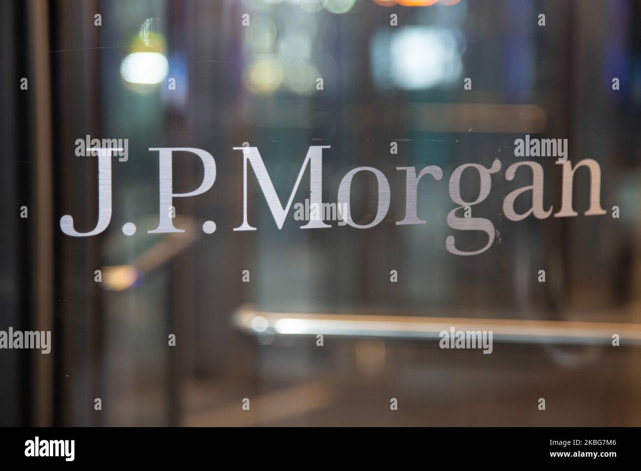The J.P. Morgan logo sign on the entrance of a glass office building in ...