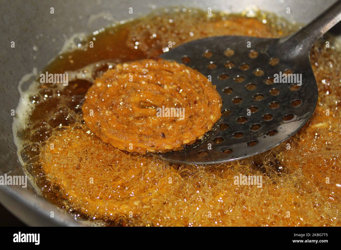 Chakali frying in oil, Indian Traditional Tea Time Snack Chakli, a deep ...