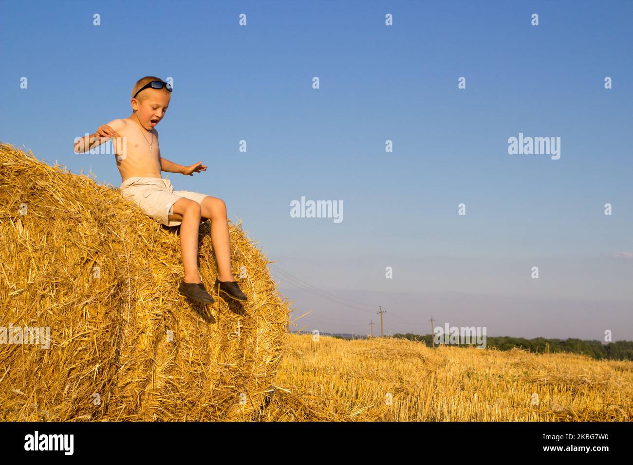 the boy jumped in the straw field Stock Photo - Alamy